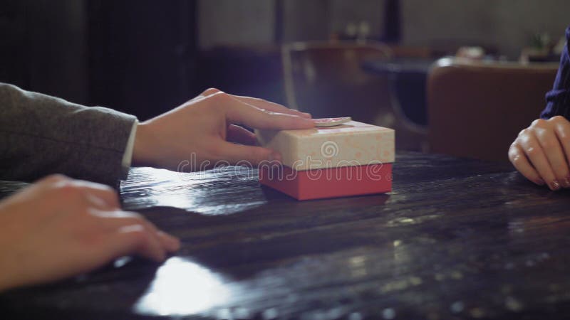A Man Takes a Gift Box from Under the Table and Puts it on the Table in ...