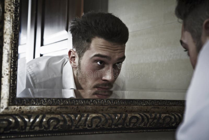 Man Takes a Look at Himself in the Mirror. Stock Photo - Image of ...