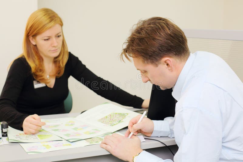 Man Takes Note and Realtor Looks at Him in Office. Stock Image - Image ...