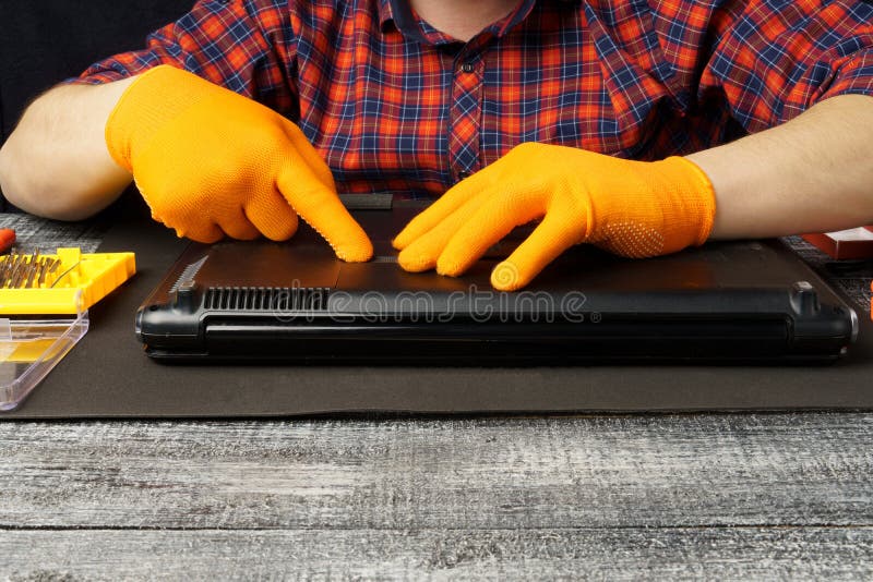 The Man is Taking Apart the Laptop.Disassembling a Laptop in a Repair ...