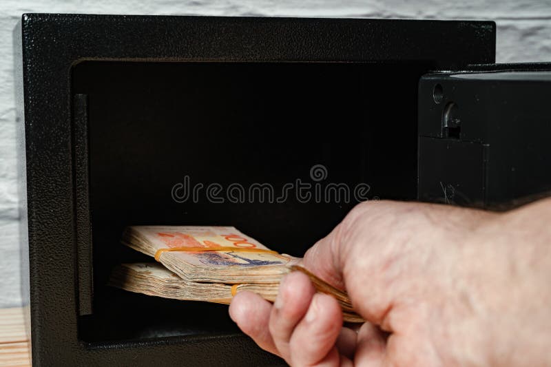 Man Taking Bundles of Cash from Inside an Open Safe Stock Photo - Image ...