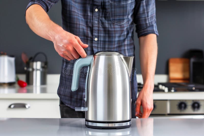 Man Taking an Electric Kettle Off the Base after Boiling Stock Photo ...