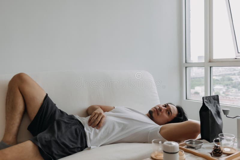 Man is Taking a Nap on the Sofa after Finish Making the Coffee. Stock ...