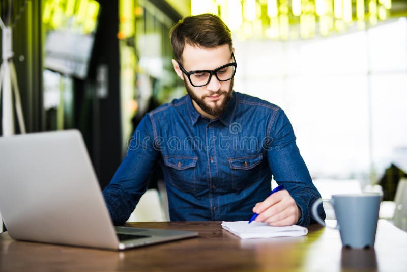 Man Taking Notes Down from His New Laptop Computer at Work in the ...