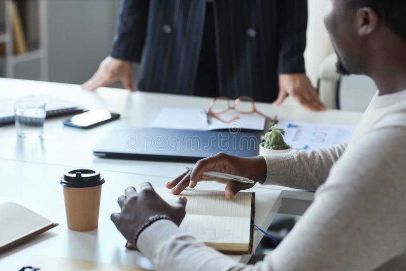Man Taking Notes in Planner during Business Meeting with Team Stock ...