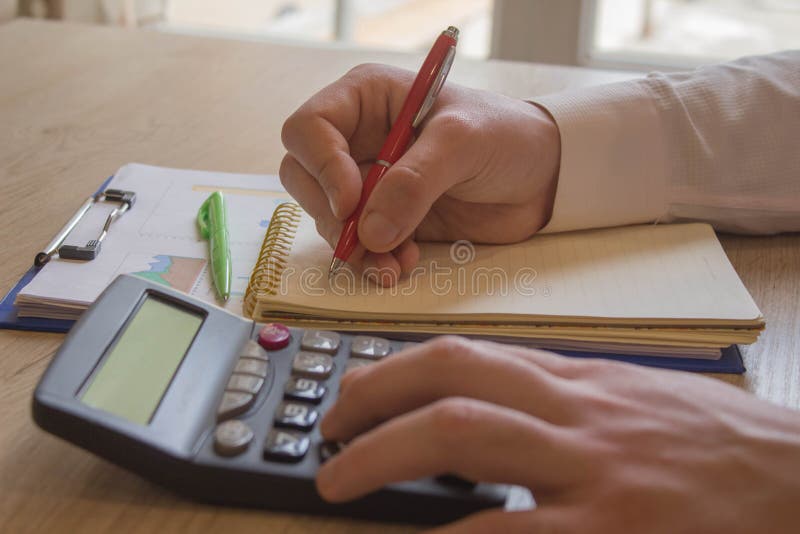 Man is Taking Notes of Saving Money in a Notebook, with a Money Jar and ...