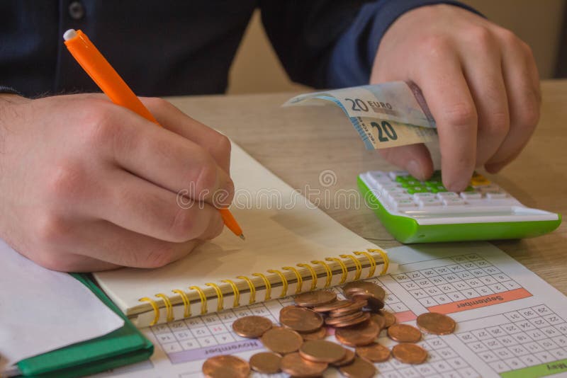 Man is Taking Notes of Saving Money in a Notebook, with a Money Jar and ...