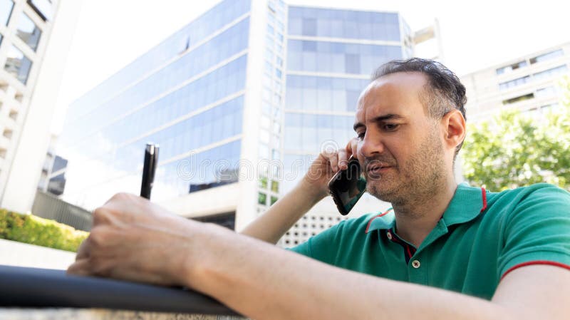 Man Taking Notes and Talking on the Phone in Front of an Office ...