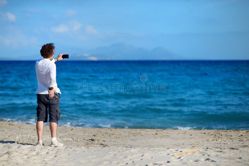 Man Taking Photo with Cell Phone on the Beach Stock Image - Image of ...