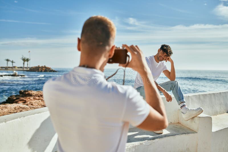 Man Taking Photos of His Boyfriend in Front of the Sea Stock Photo ...