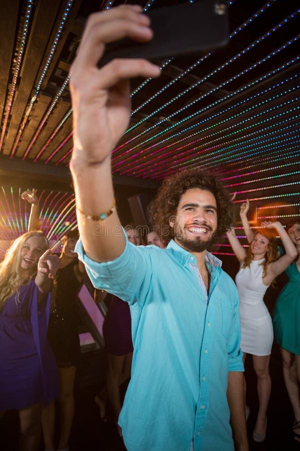 Man Taking a Selfie from Mobile Phone while Friends Dancing on Dance ...