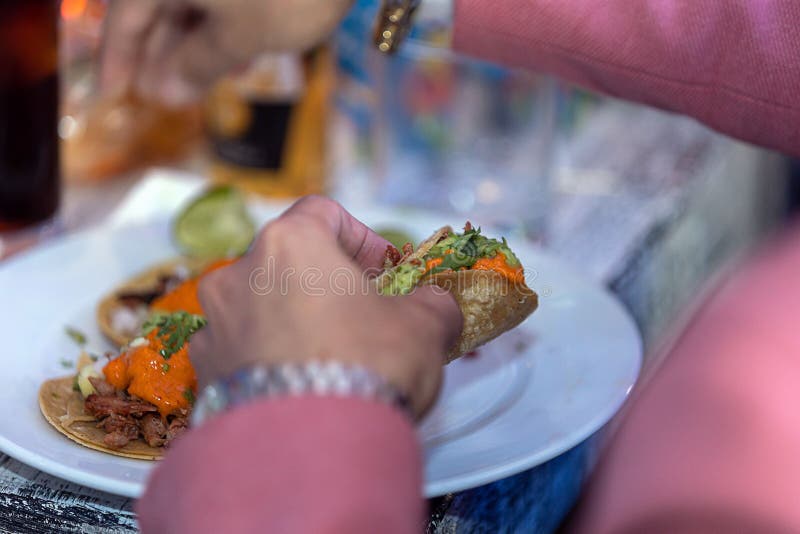 Man Taking Traditional Mexican Pastor Tacos from a White Plate Stock ...