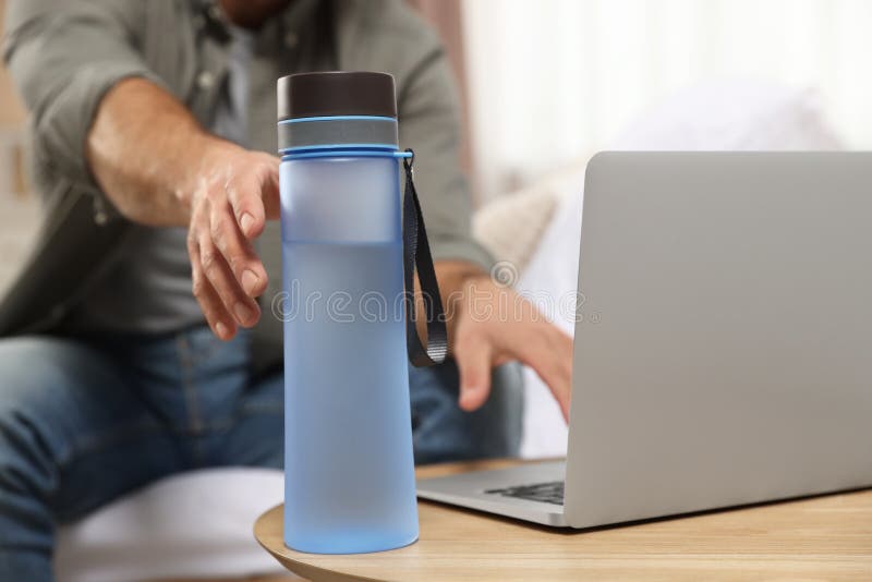 Man Taking Transparent Plastic Bottle of Water while Working on Laptop ...