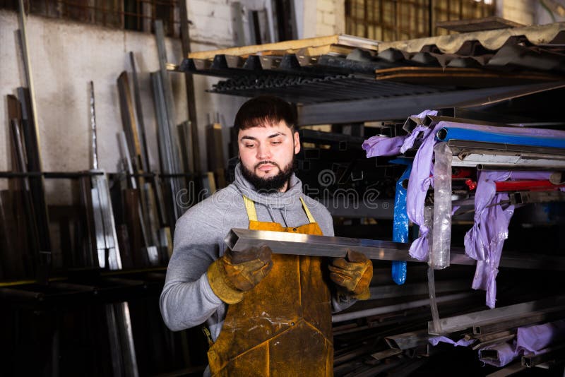 Man Taking Tubes from Rack in Workshop Stock Photo - Image of portrait ...