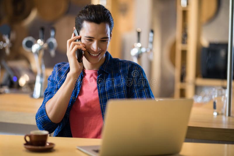 Man Talking on Mobile Phone while Using Mobile Phone in Restaurant ...