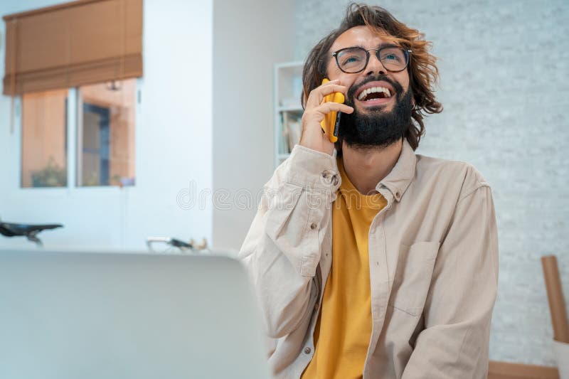 Man Talking on the Phone Laughing in His Modern Workspace at Home ...