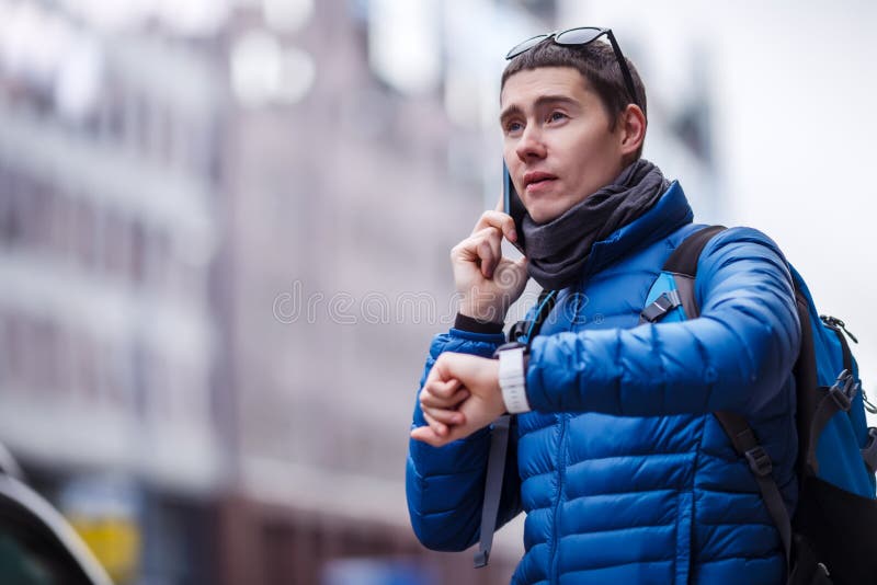 Man Talking on Phone and Looking at Smartwatch Stock Photo - Image of ...