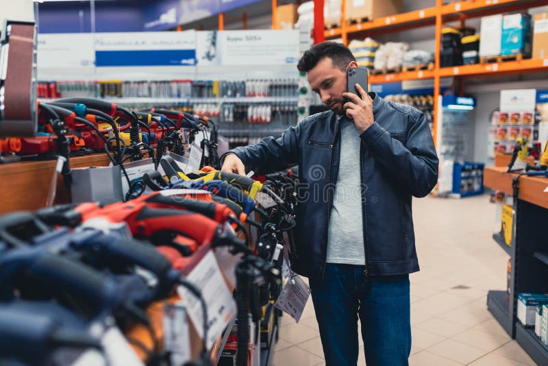 Man Talking on the Phone in the Power Tool Department of a Hardware ...