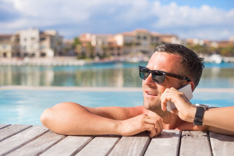 Man Talking on Phone while Relaxing in the Swimming Pool Stock Photo ...