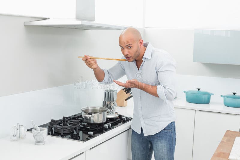 Man Tasting Food while Preparing in Kitchen Stock Image - Image of ...