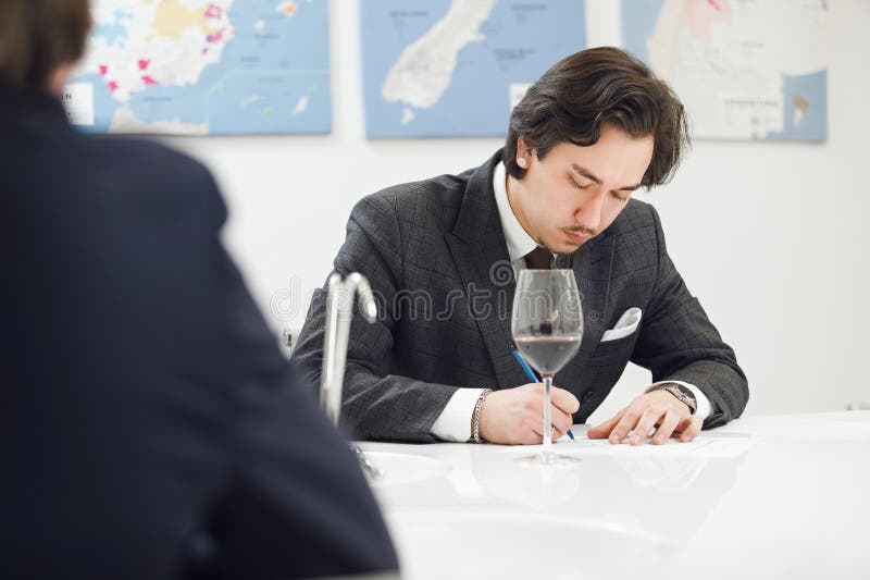 Man Tasting Red Wine and Making Notes To Degustation Card. Sommelier ...