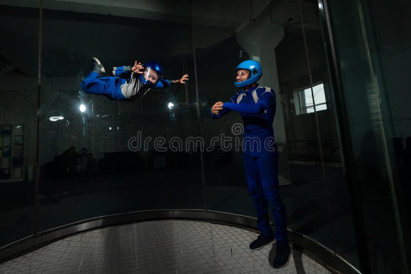 A Man Teaches a Boy To Fly in a Wind Tunnel. Lack of Gravity. Stock ...