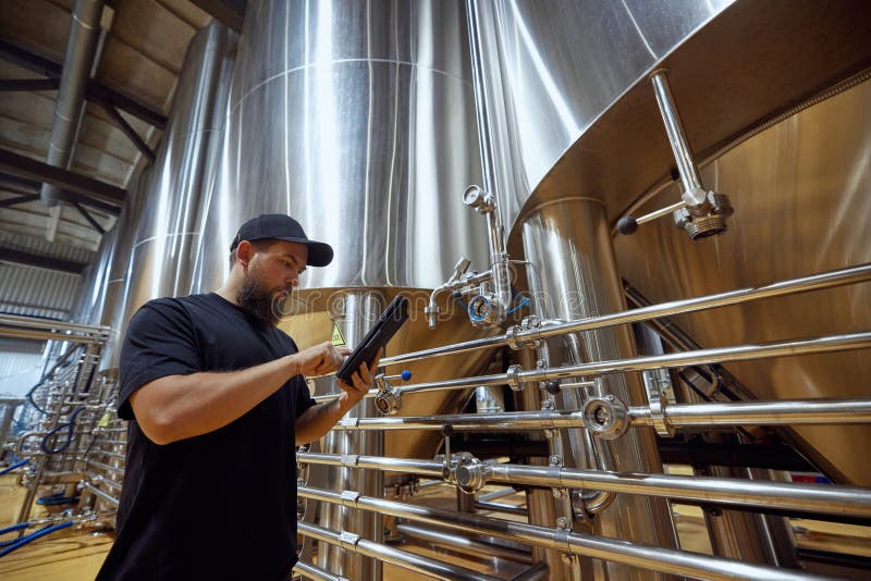 Man, Technologist with Tablet in Hand Checking the Brewing System ...