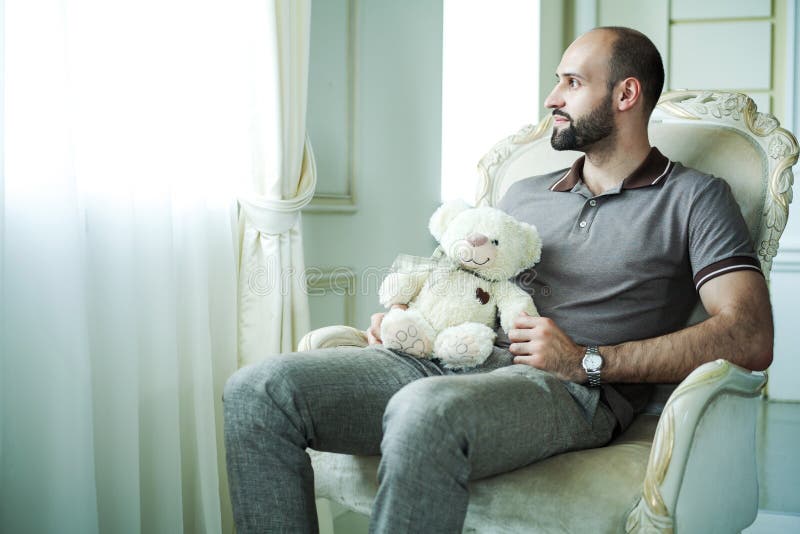 Man with teddy bear stock photo. Image of cuddle, armchair - 40872546