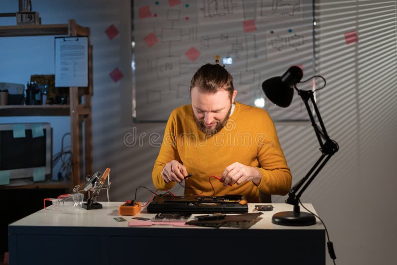 Man Testing Laptop Motherboard Using Multimeter Sitting on His ...