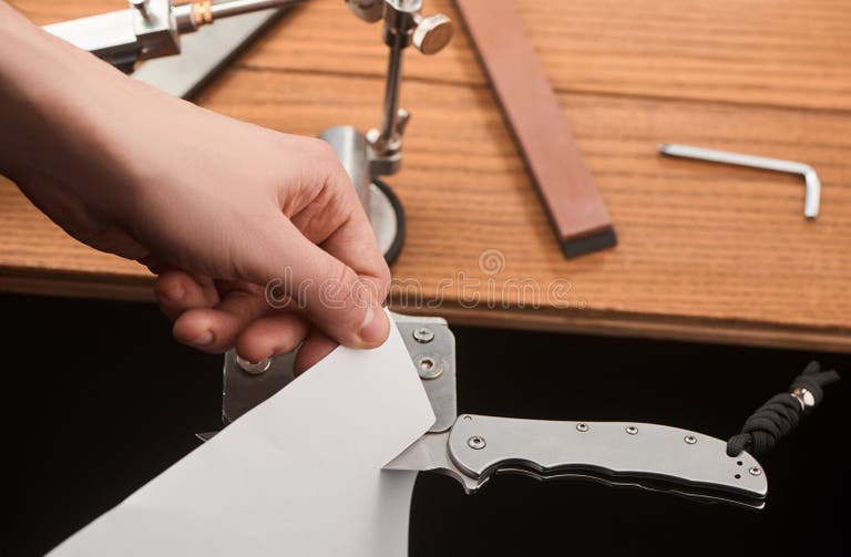 Man Testing the Sharpness of a Blade with a Paper Sheet Stock Photo ...