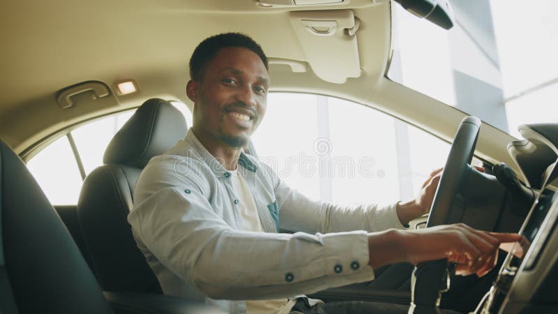 A Man Tests a New Car. Side View of Focused African Man Sitting on ...