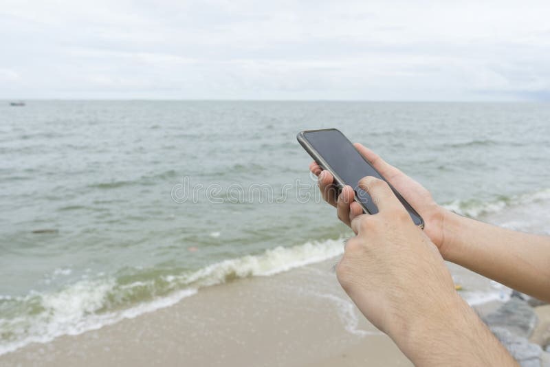 A Man Texting Cellphone on the Beach Stock Image - Image of phone, left ...