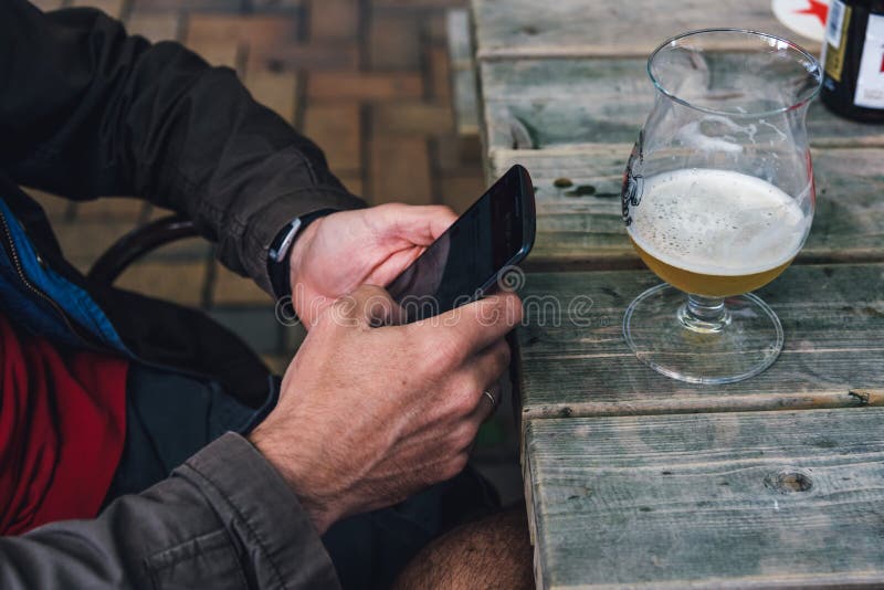 Man Texting on Phone while Drinking Beer Sitting on a Bar Stock Image ...