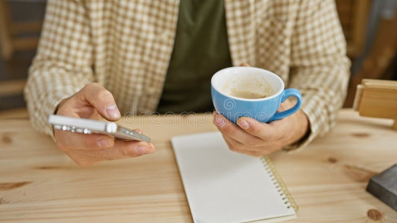 A Man Texts on a Smartphone while Taking a Coffee Break in a Wooden ...