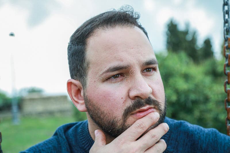 Man Thinking while on the Swing Stock Photo - Image of expression ...