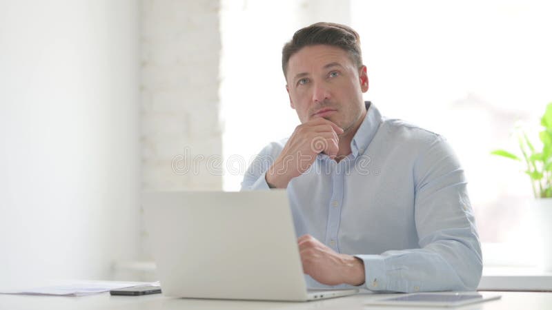 Man Thinking while Working on Laptop in Office Stock Photo - Image of ...