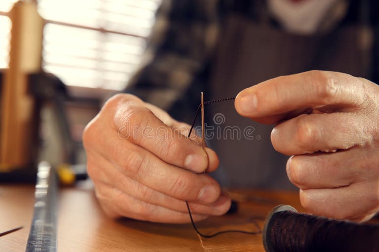 Man Threading Needle for Leather Working Stock Photo - Image of product ...