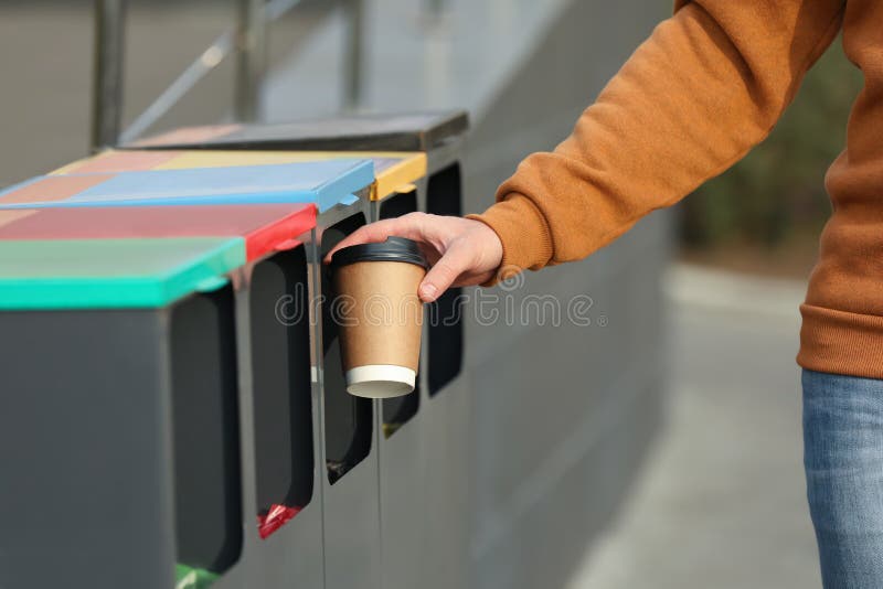 Man Throwing Coffee Cup into Bin Outdoors. a Hand Throws a Paper Cup ...