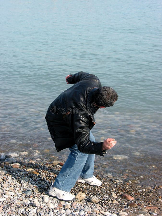 Man throwing pebbles stock photo. Image of people, blue - 652598