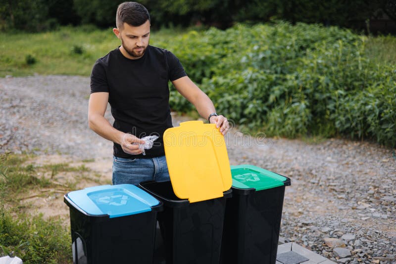 Man Throwing Plastic Bag into Recycling Bin on Back Yard. Different ...