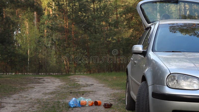 A Man Throws Away Waste, Garbage, Plastic from the Trunk of the Car ...