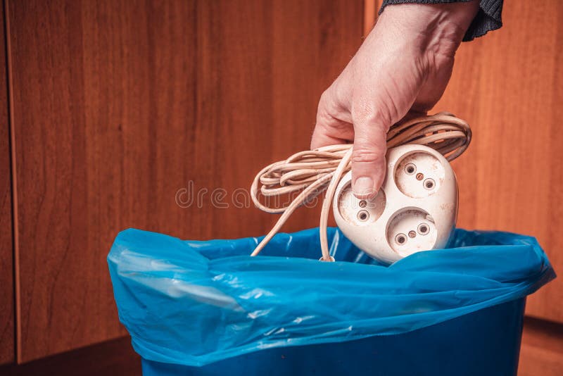 A Man Throws an Electric Extension Cord into the Trash Can. Man`s Hand ...