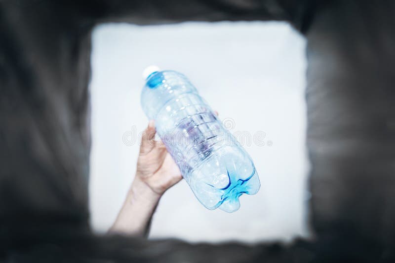 Man Throws Empty Plastic Bottle into a Trash Can. Bottom View from the ...