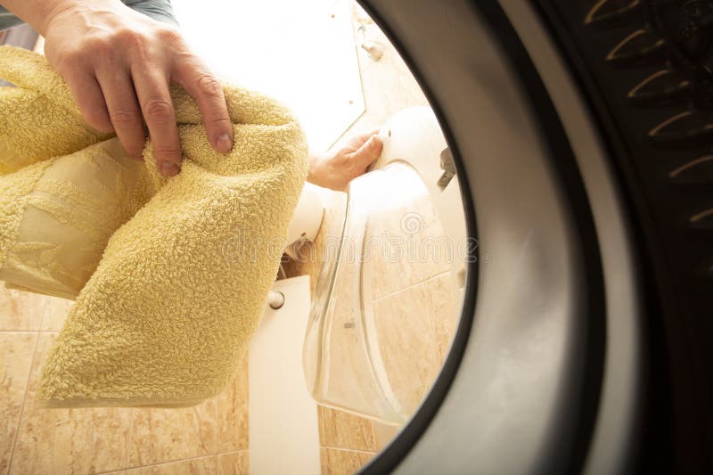 A Man Throws Laundry into a Washing Machine.Everyday Household Chores ...