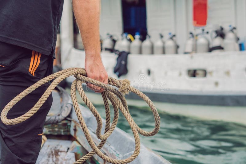 A Man Throws a Rope To Moor on a Diver Ship Stock Photo - Image of ...