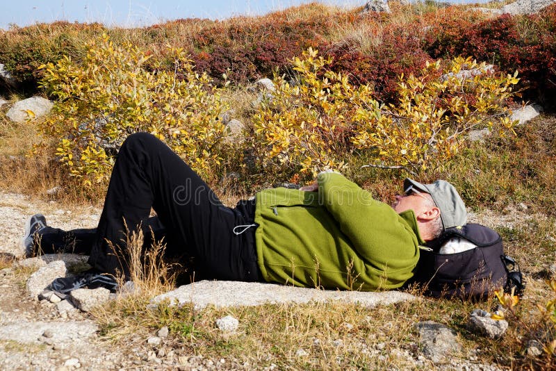 A Man Tired during a Hike Rests on the Ground Stock Image - Image of ...