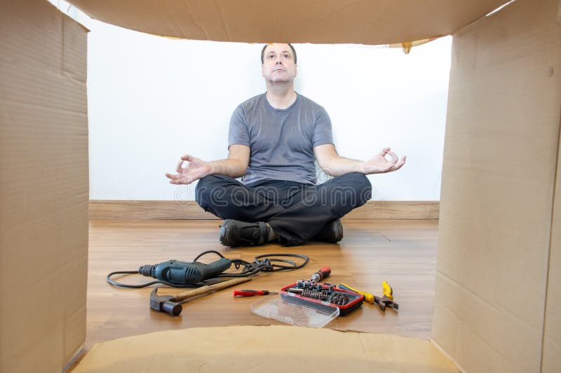 A Man with Tools Meditates by an Open Cardboard Box. Stock Photo ...