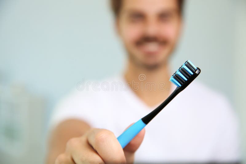 Man with Toothbrush on Blurred Background Stock Photo - Image of ...