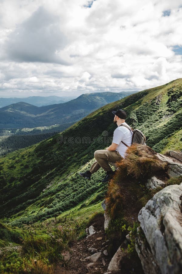 Man on Top of a Mountain Sitting on a Rock Stock Image - Image of ...