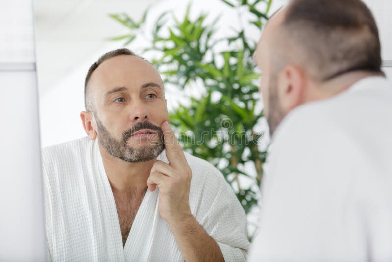 Man Touching Beard and Face Looking in Mirror Stock Image - Image of ...